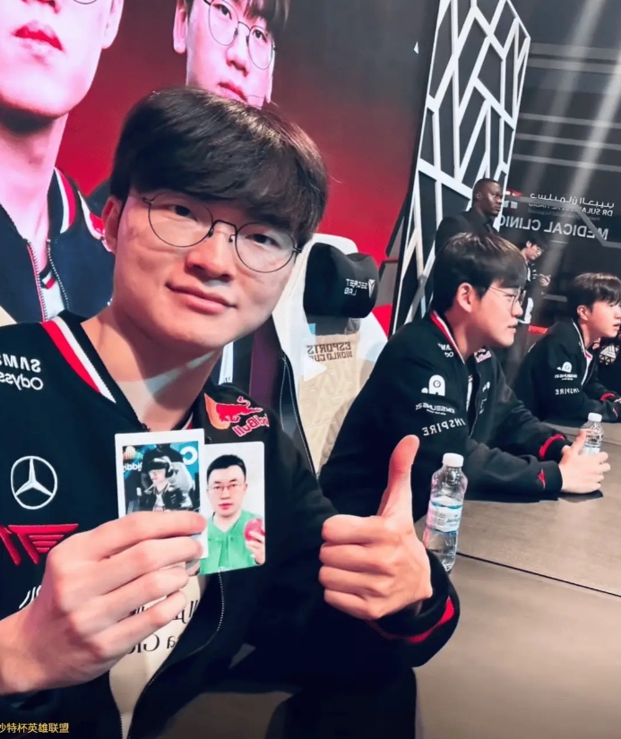 xiaohu粉丝拿选手拍立得去找Faker合照，Faker手举xiaohu拍立得，并比出点赞经典手势-直播吧